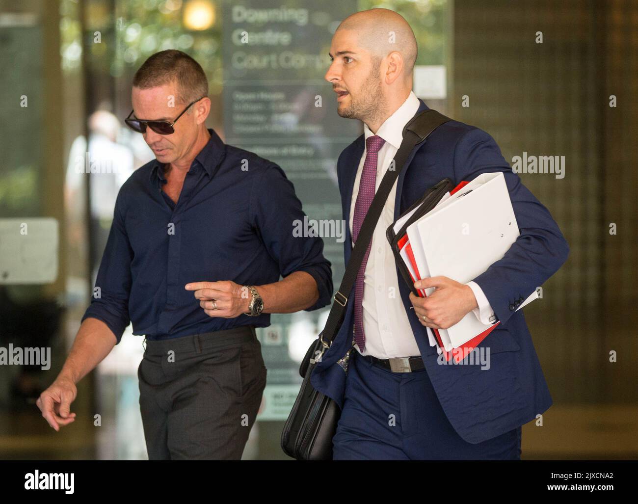 Masseur Jamie Burdette (left) leaves the Downing Centre court in Sydney ...
