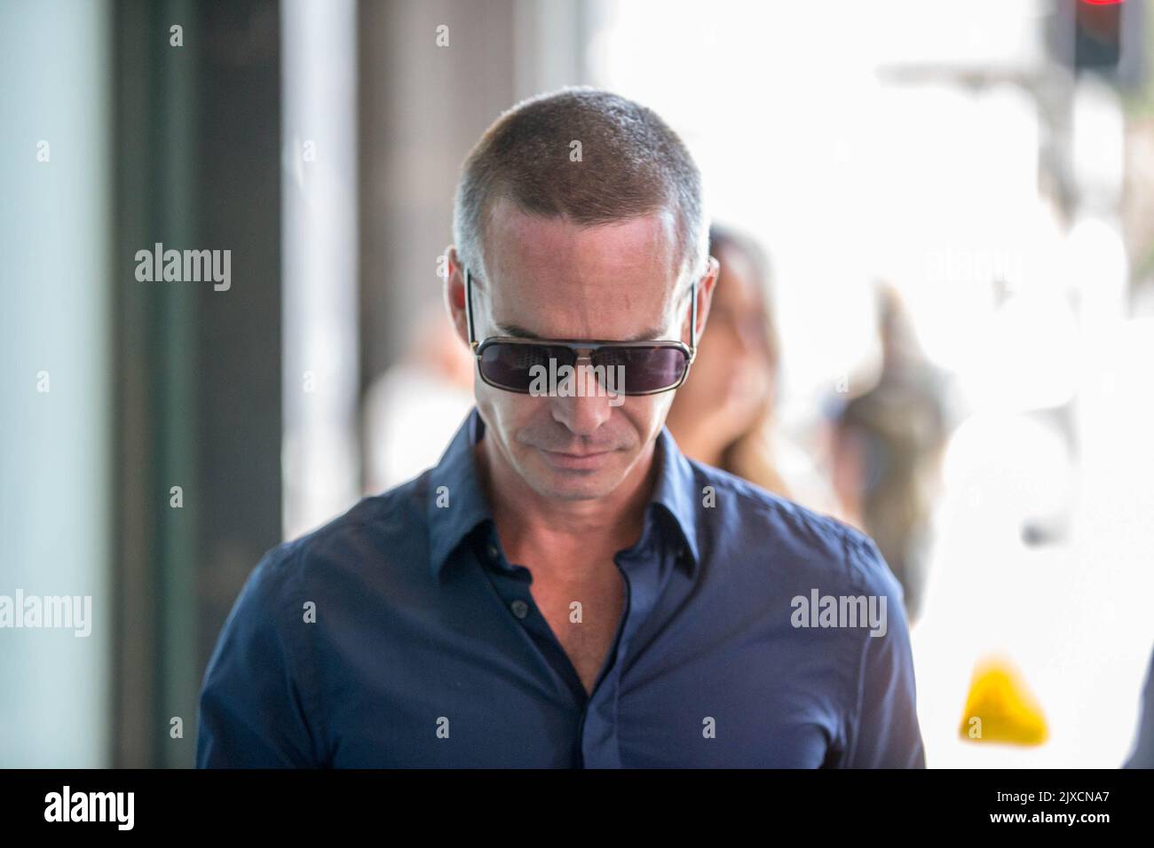 Masseur Jamie Burdette (left) leaves the Downing Centre court in Sydney ...