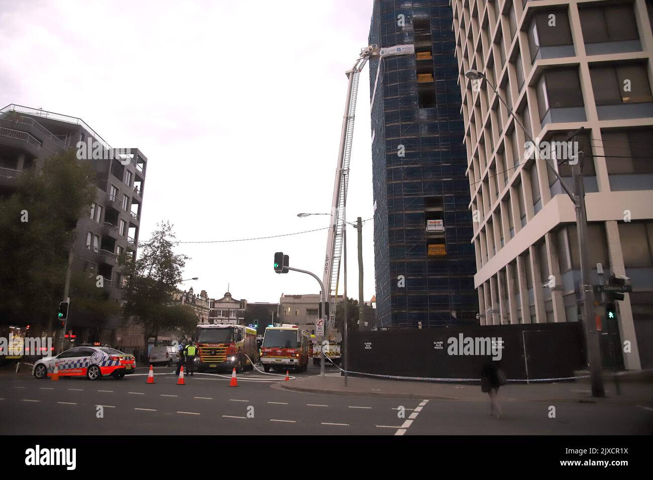 Police and fire crews work to control a fire burning in a high-rise ...