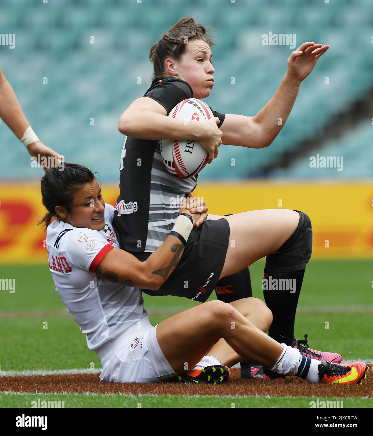 Emily Scarratt of England is tackled by Nicole Heavirland of the USA ...