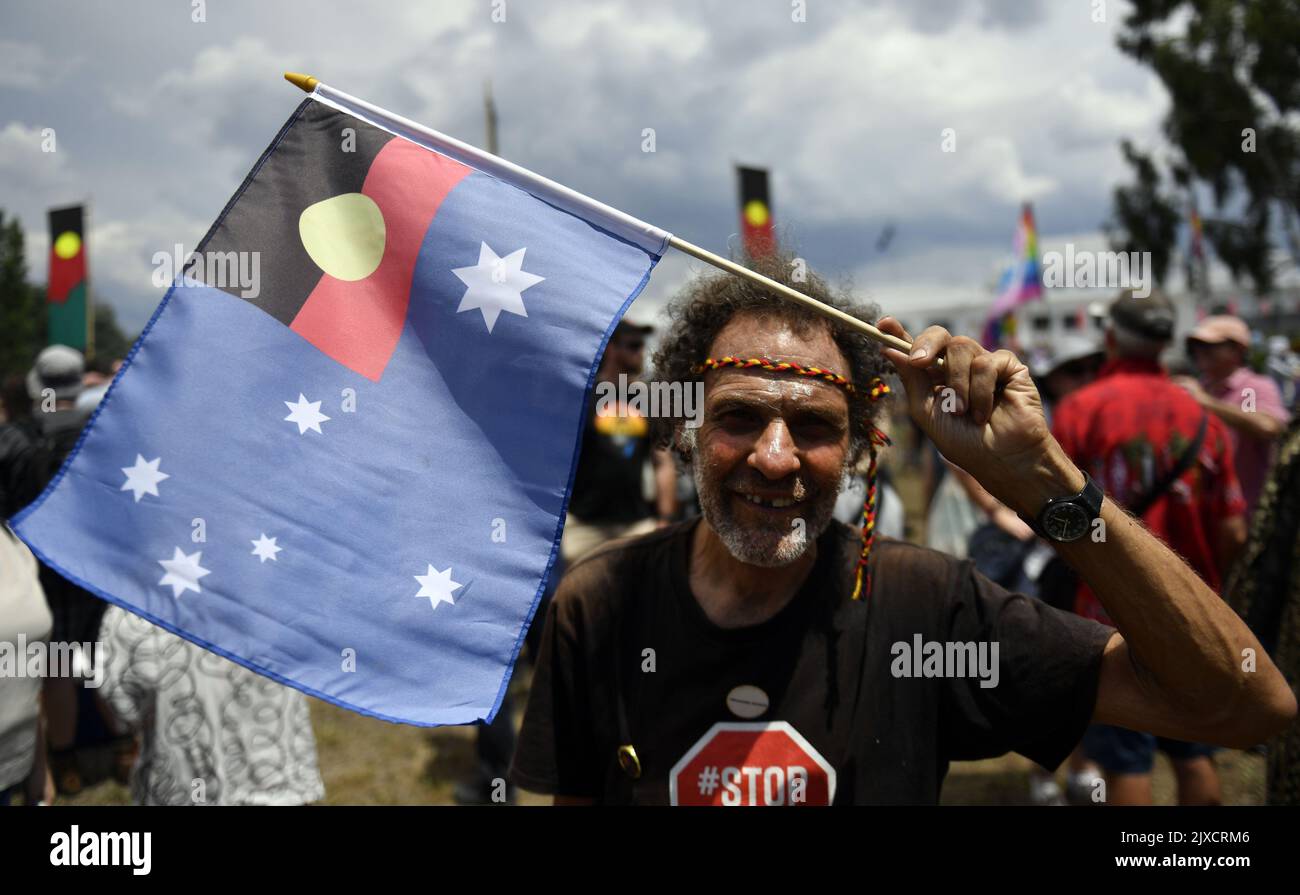 A man hold a flag where the Aboriginal flag replaces the Union Jack ...