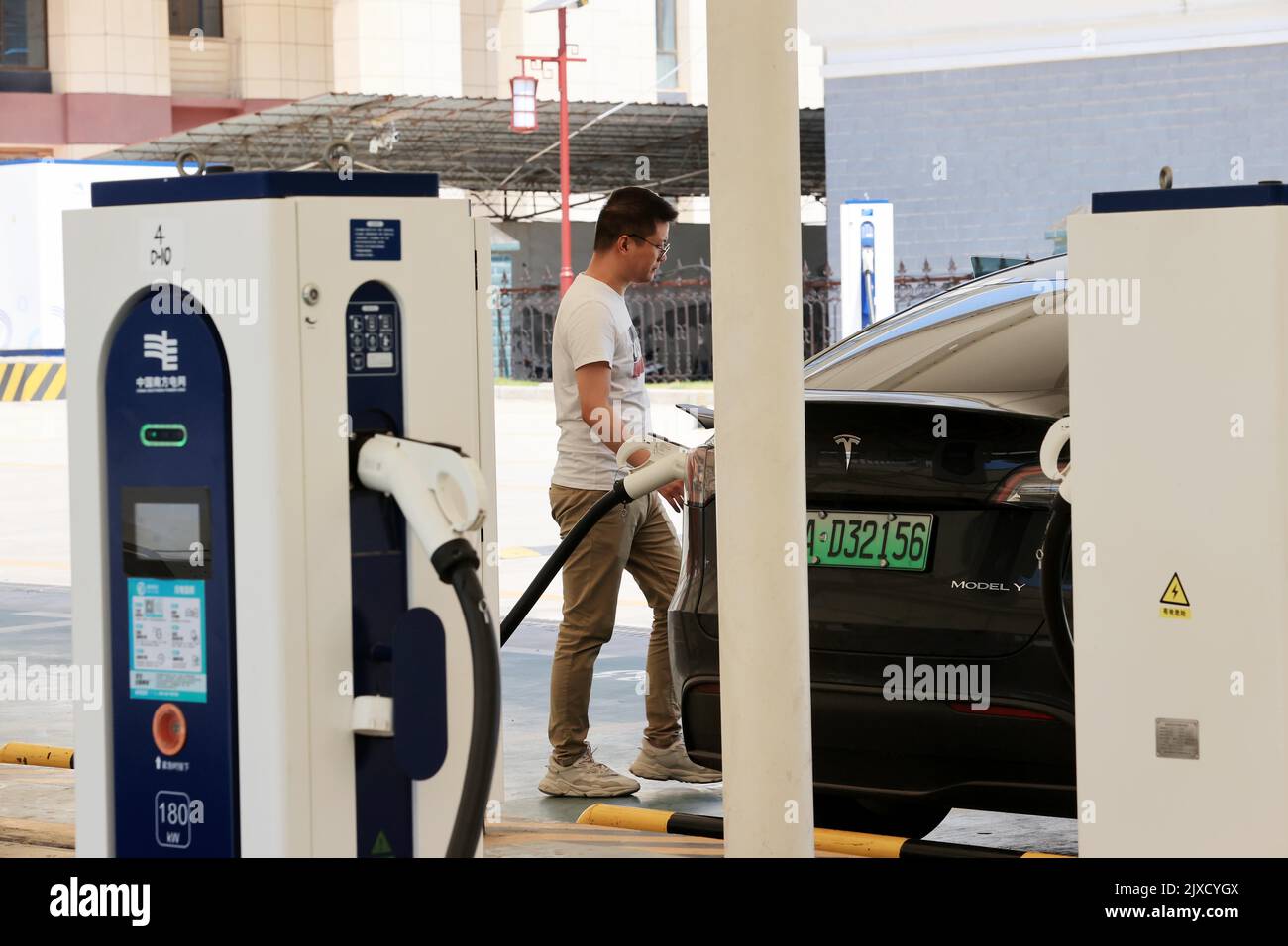 LIUZHOU, CHINA - SEPTEMBER 7, 2022 - An electric vehicle owner charges ...