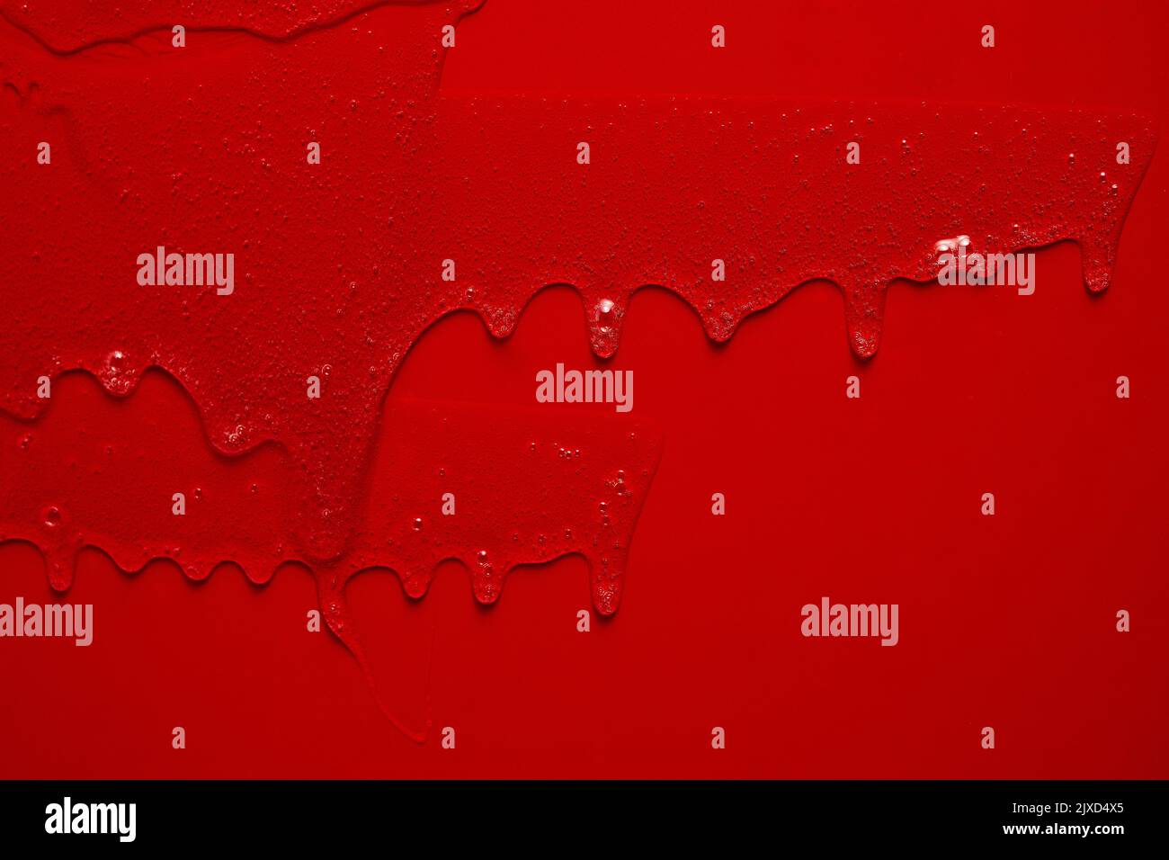 Cream liquid gel serum flows down red silver texture Stock Photo - Alamy
