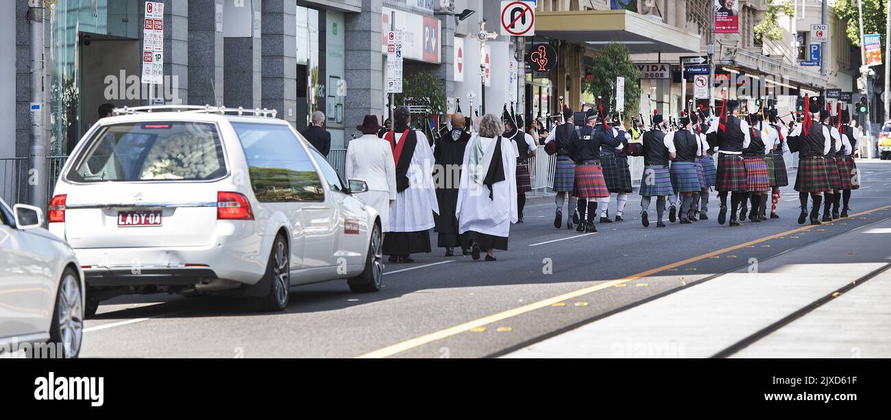 A pipe band lead the procession down Flinders Street following a ...
