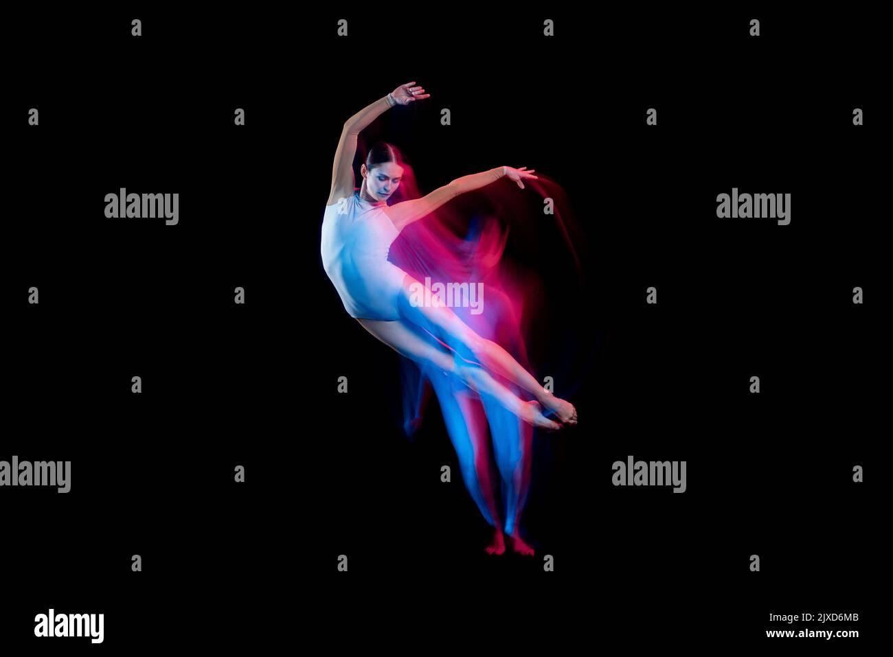 Graceful ballerina dancing on dark background in mixed neon light ...