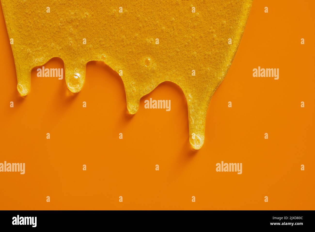 Cream liquid gel serum flowing down on yellow texture Stock Photo - Alamy