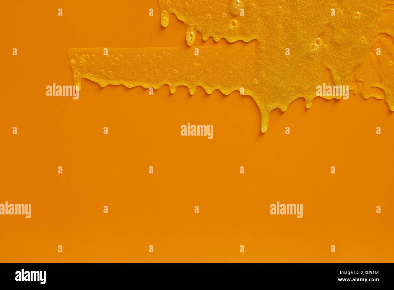 Cream liquid gel serum flowing down on yellow texture Stock Photo - Alamy