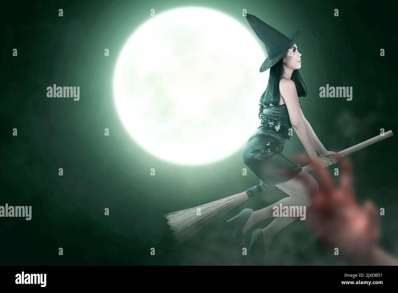 Asian witch woman with hat flying on a magic broomstick with a full ...