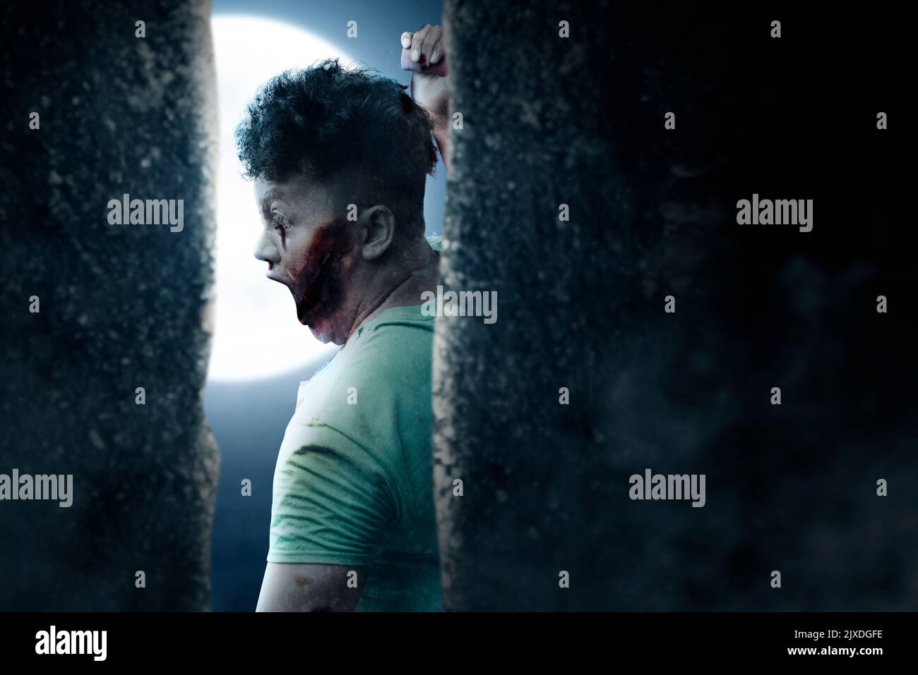 Scary zombie with blood and wound on his body standing with full moon ...