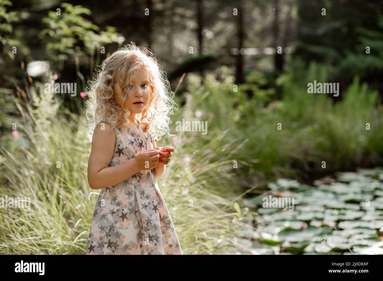 Portrait of upset crying little girl with long fluffy curly hair ...