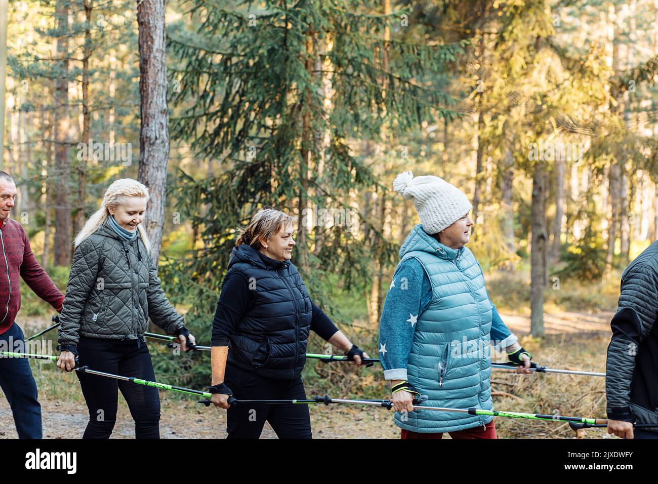 Sideview of people making Scandinavian walking one by one, hold ...