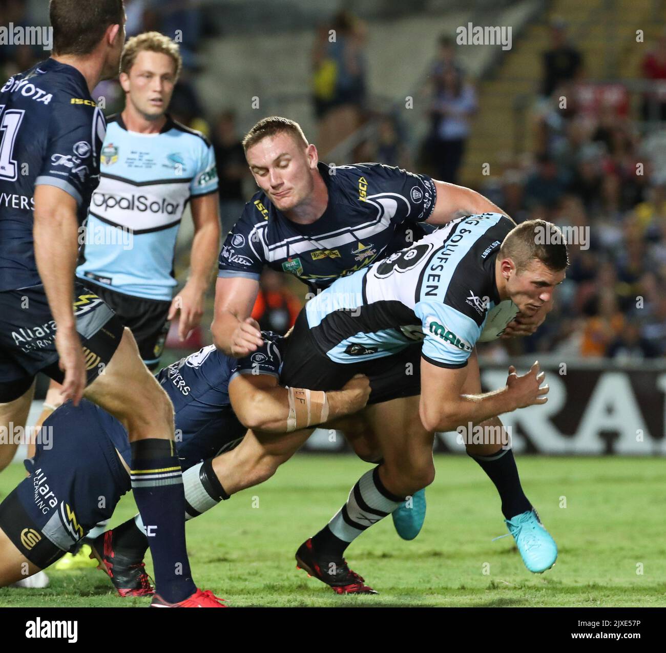 Kurt Capewell of the Sharks is wrapped up by Cowboys defence during the ...