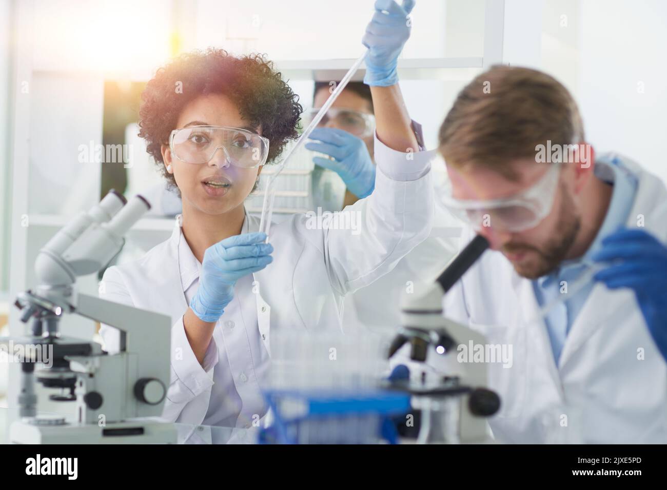 Team of Scientists Working Using Microscope, Analysing Microbiology ...
