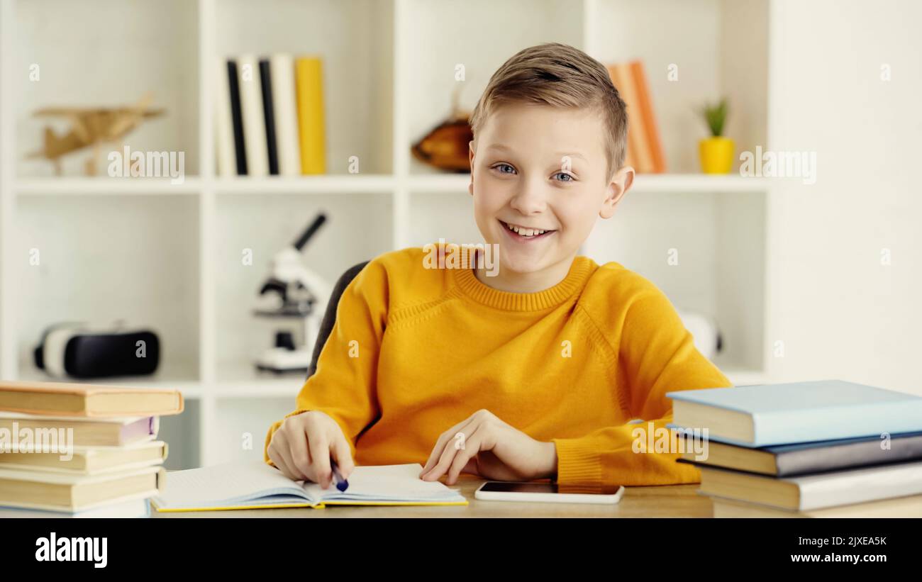 Boy smartphone notepad doing homework hi-res stock photography and ...