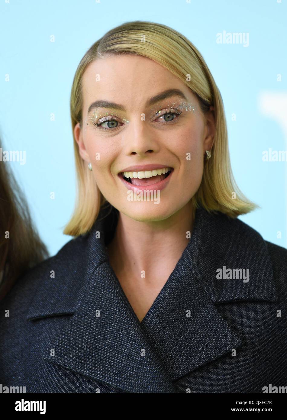 Margot Robbie smiles as she poses for photographers as she arrives to ...