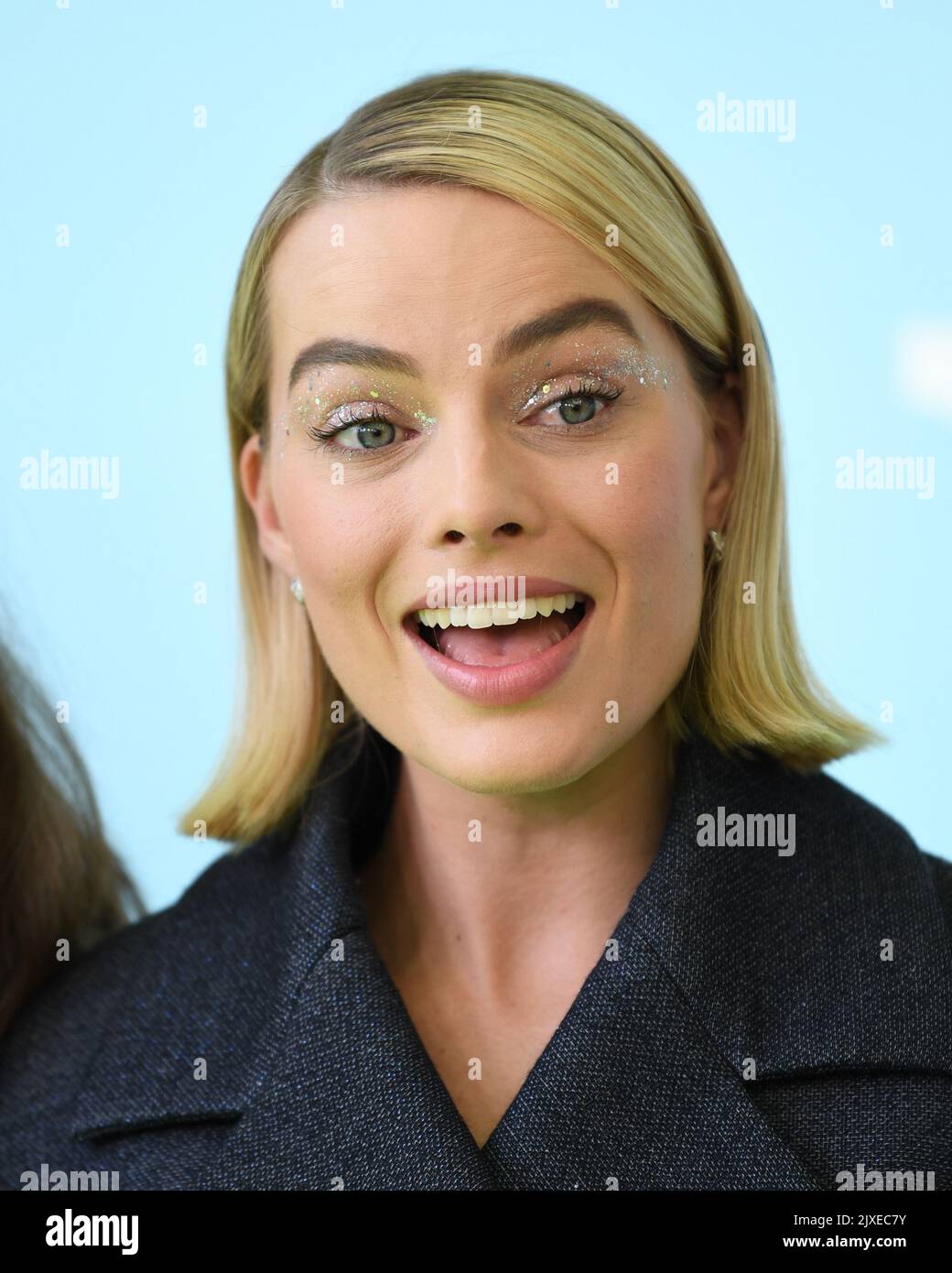 Margot Robbie smiles as she poses for photographers as she arrives to ...