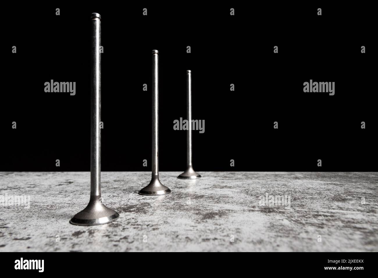Car engine valves on the table and black background. Part of an ...