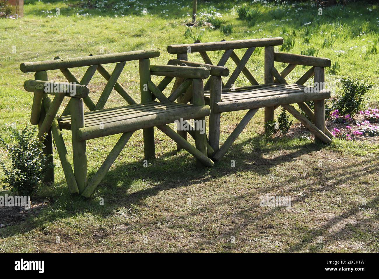 Two Wooden Rustic Seats in a Garden Setting Stock Photo - Alamy