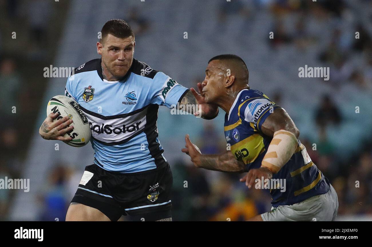 Joshua Dugan of the Sharks evades the tackle of Manu Ma'u of the Eels ...