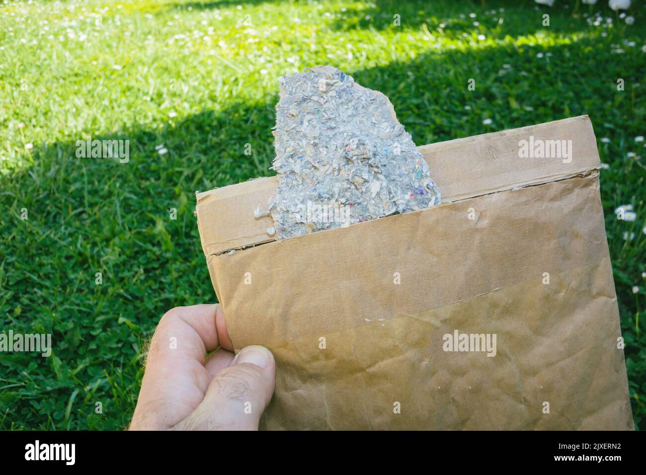 POV male hand holding parcel transportation envelope made from recycled ...