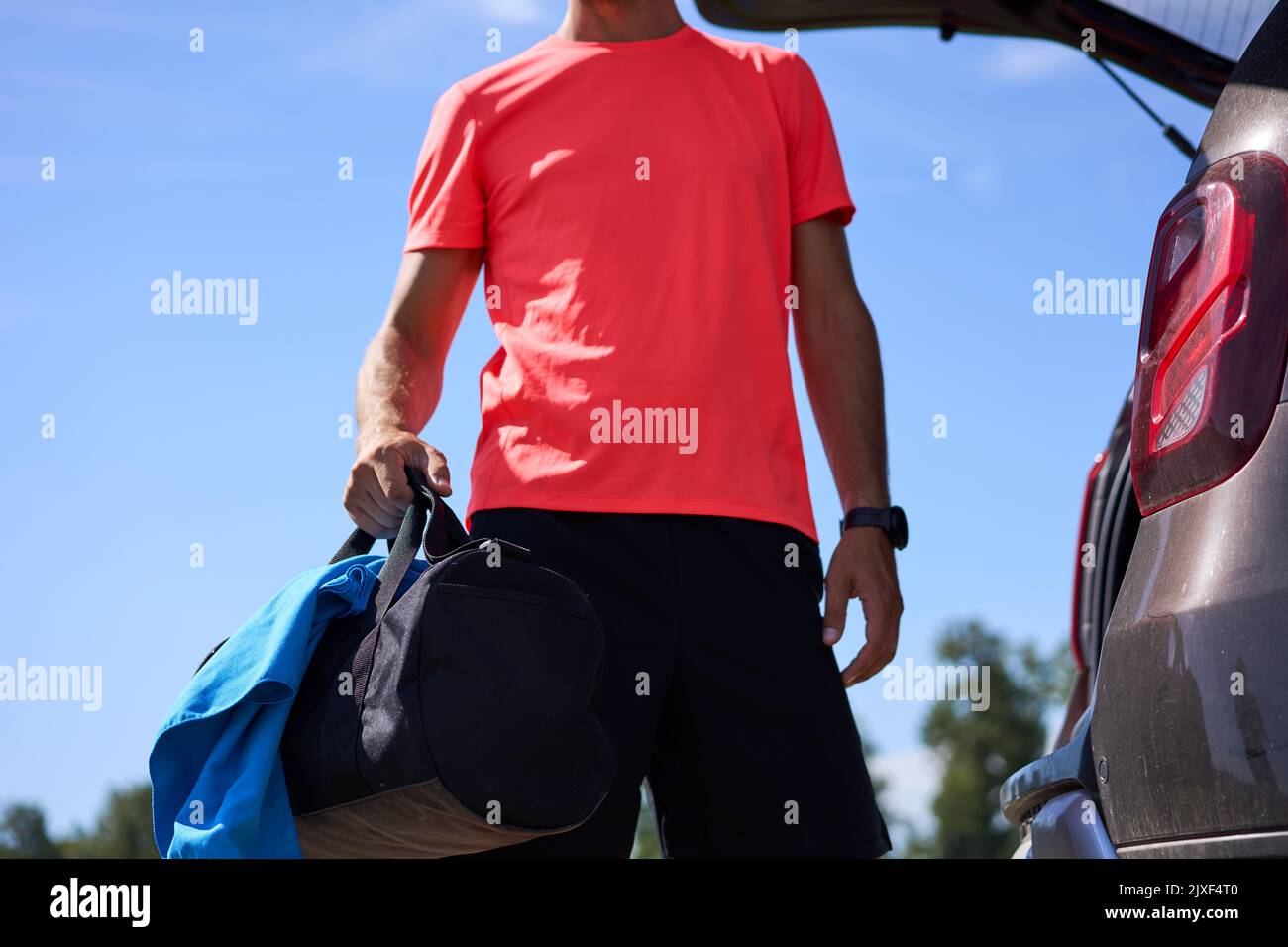 Sportsman getting bag out of trunk outdoors. Concept of sport lifestyle ...