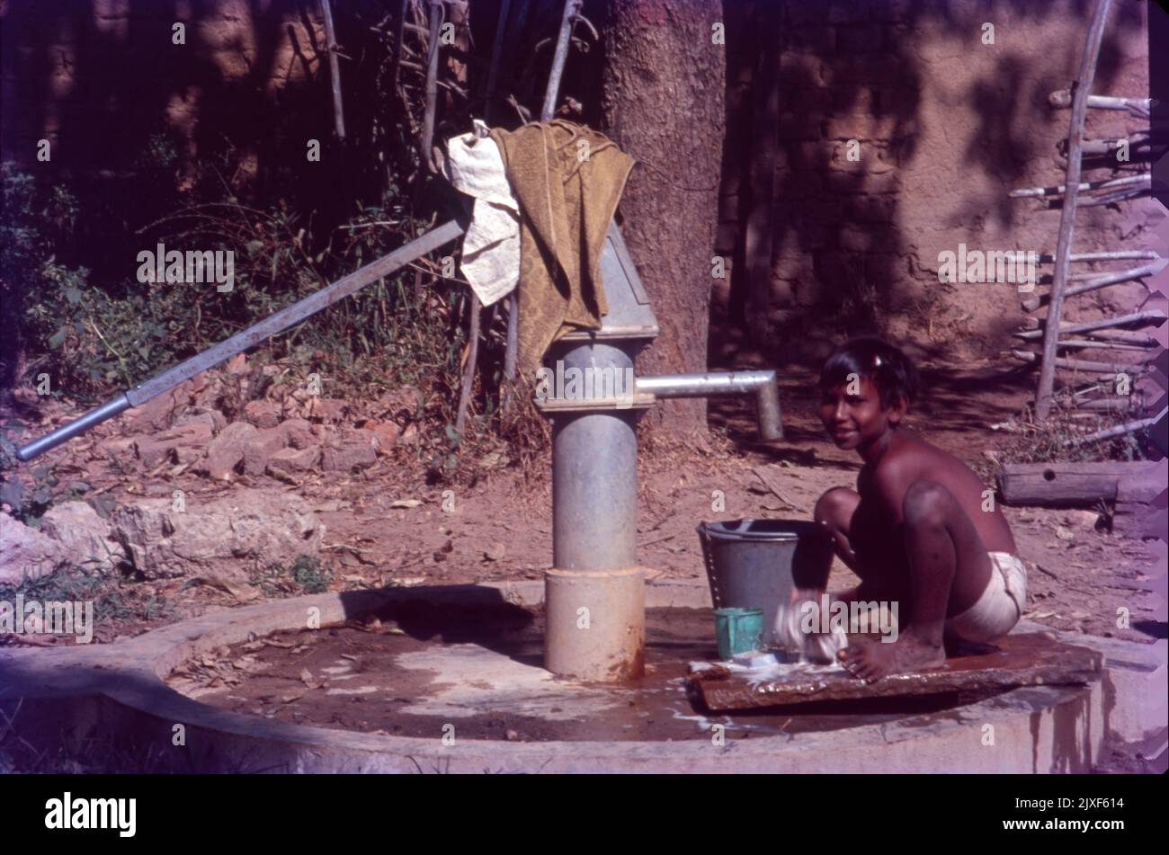 Child washing clothes near water pump Stock Photo - Alamy
