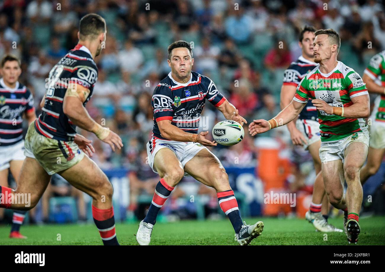 Cooper Cronk (centre) of the Roosters runs with the ball during the ...