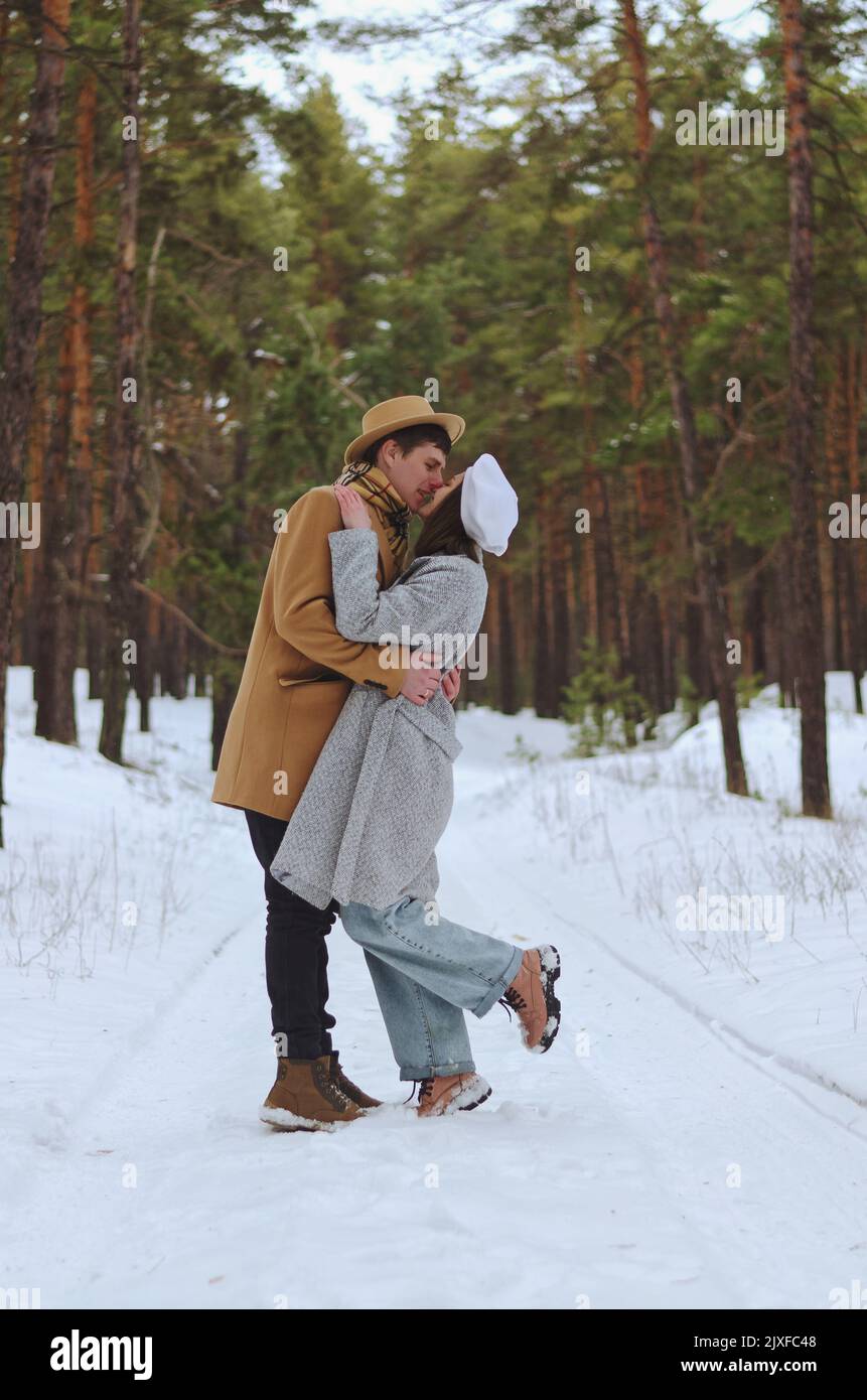 funny family, couple in snowy park, forest. Young woman, girl and man ...