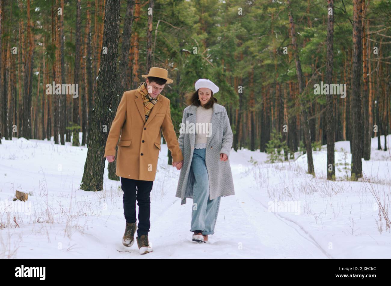 funny family, couple in snowy park, forest. Young woman, girl and man ...