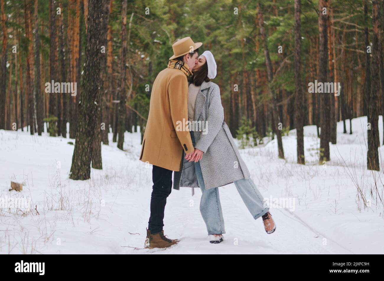 funny family, couple in snowy park, forest. Young woman, girl and man ...