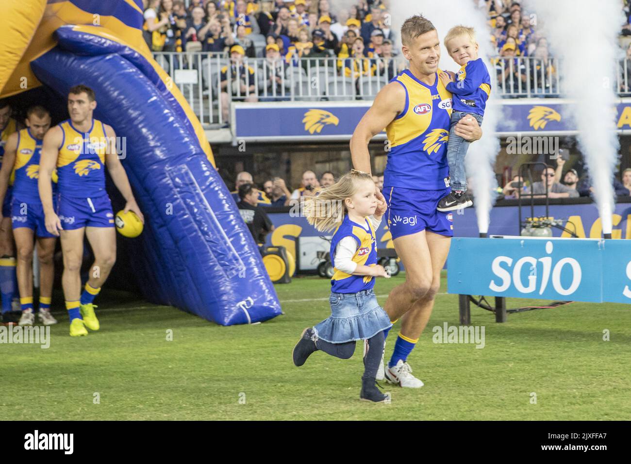 Mark LeCras of the Eagles runs out with his children to celebrate his ...