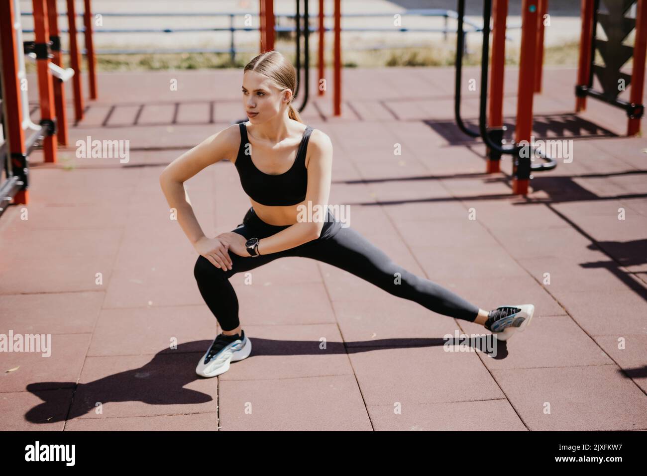 squatting.young beauty girl do exercises at the stadium Stock Photo - Alamy