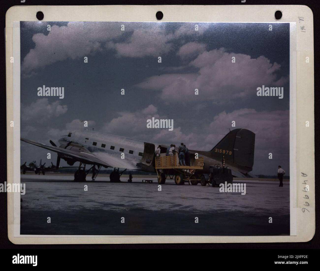 Cargo Is Loaded Into A Douglas C-47. A Guard Is Standing By The Tail Of ...