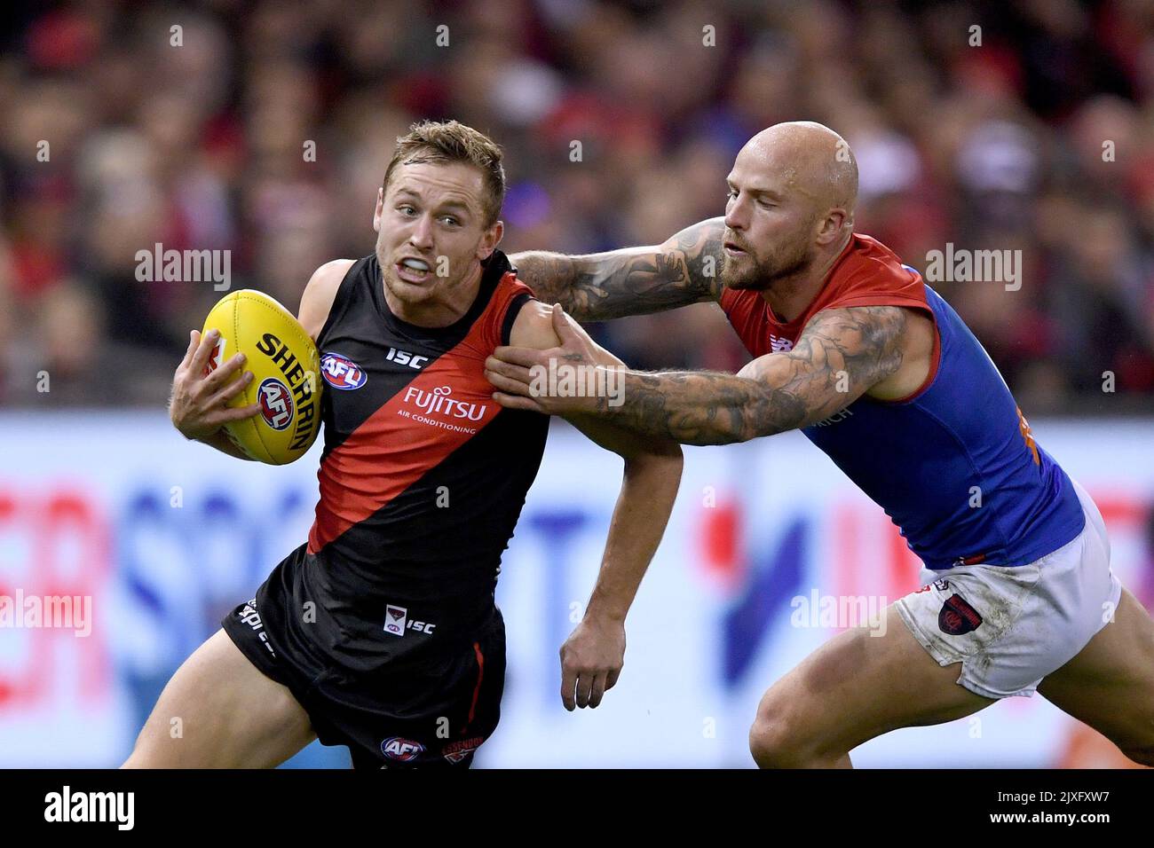 Devon Smith of the Bombers is tackled by Nathan Jones of the Demons during the Round 6 AFL match ...