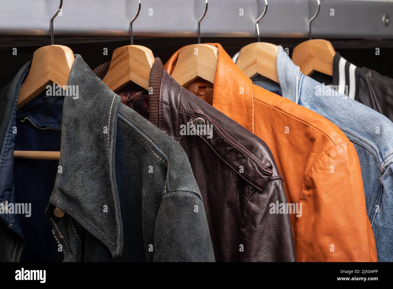 Various vintage suede leather and jeans jackets on hanger rack in a ...