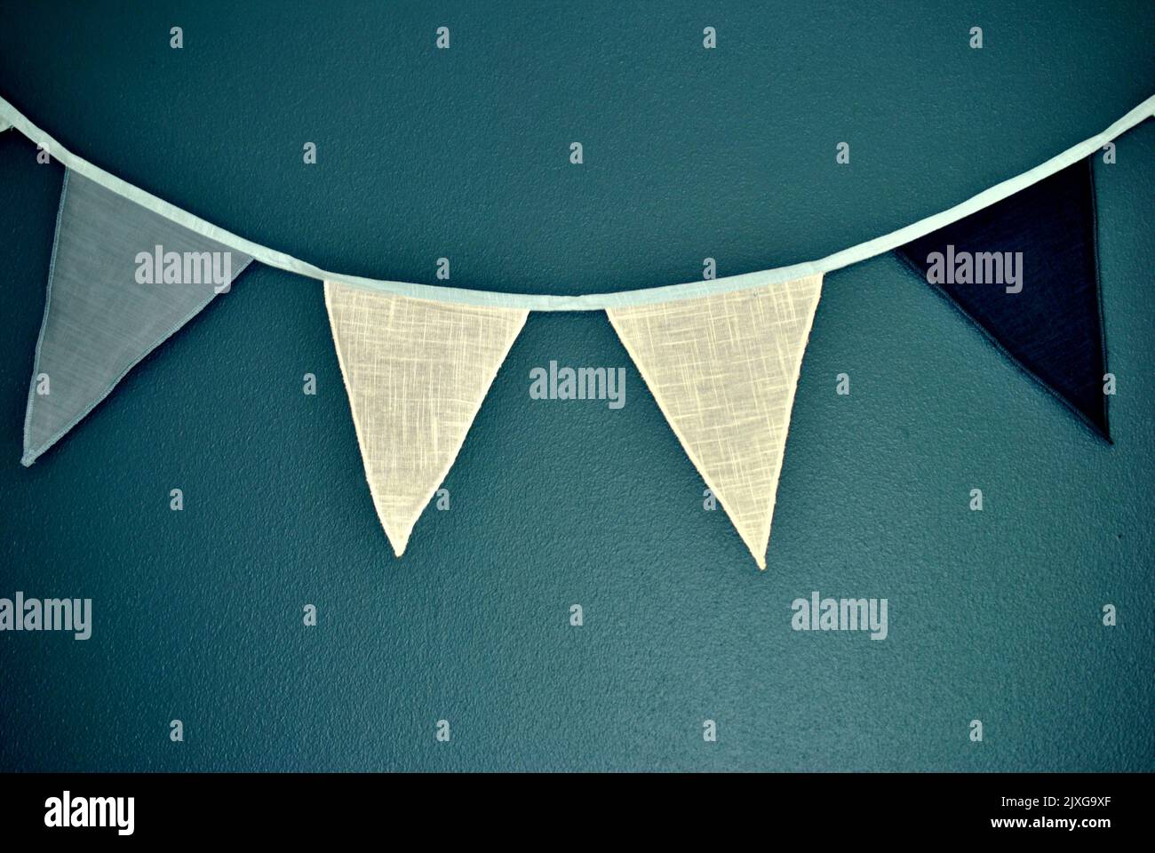 close-up of four pennants in front of turquoise blue green background ...
