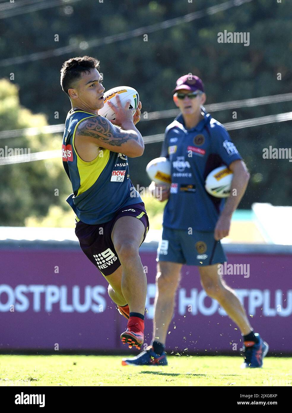 Kodi Nikorima receives the ball as coach Wayne Bennett looks on during ...