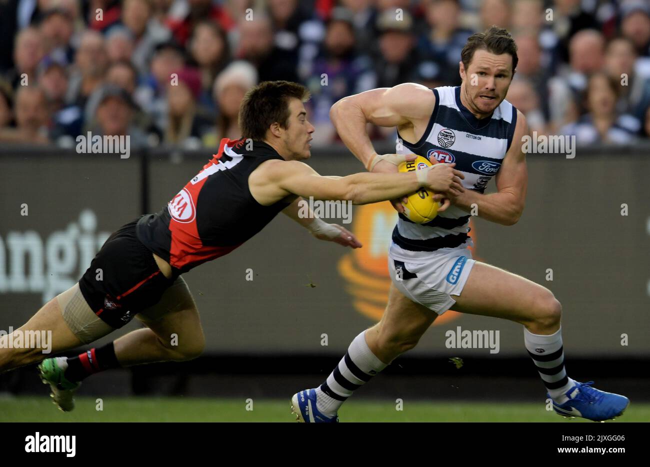 Patrick Dangerfield of the Cats (right) is tackled by Zach Merrett of ...