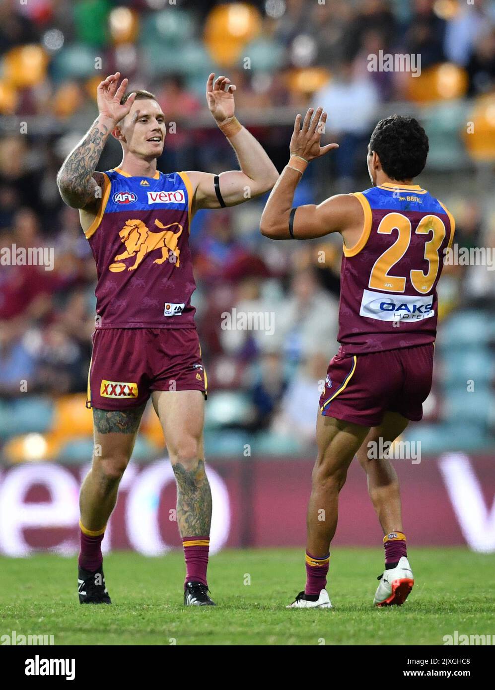 Dayne Beams (left) of the Lions celebrates kicking a goal with Charlie ...