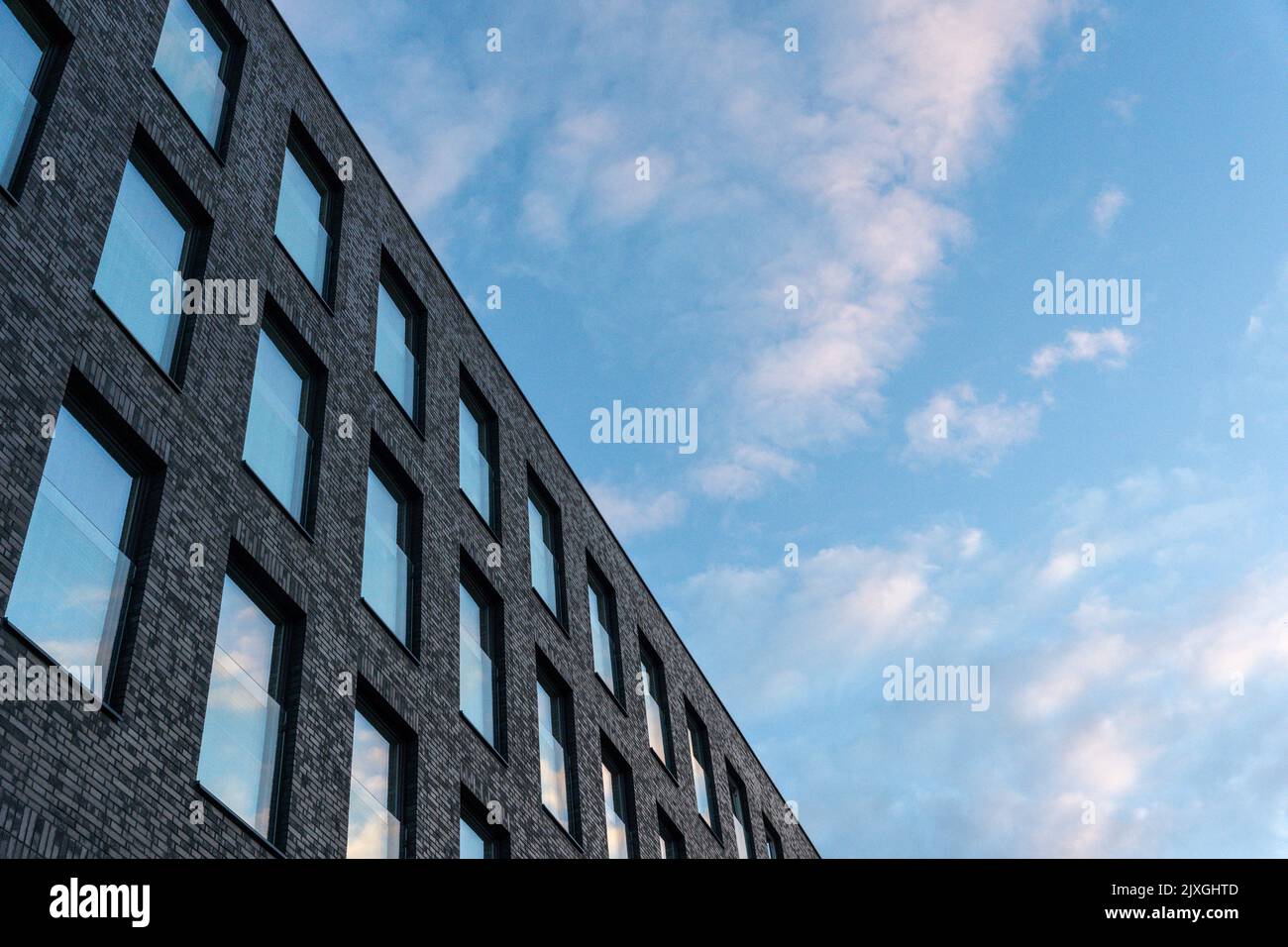 Modern unrecognised buildings with sunset sky reflected in window ...