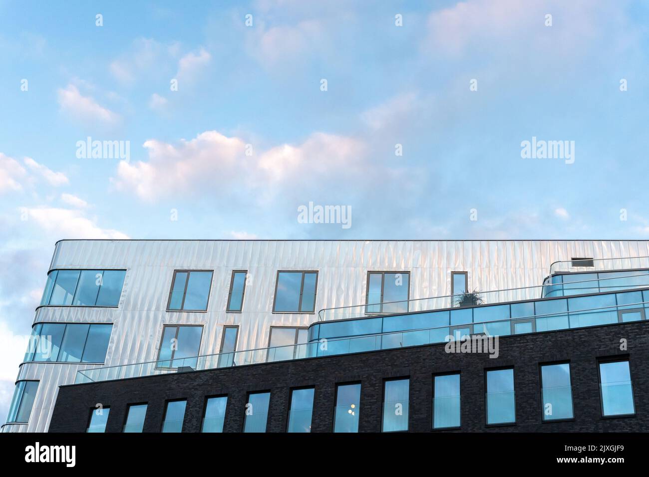 Modern unrecognised buildings with sunset sky reflected in metallic ...