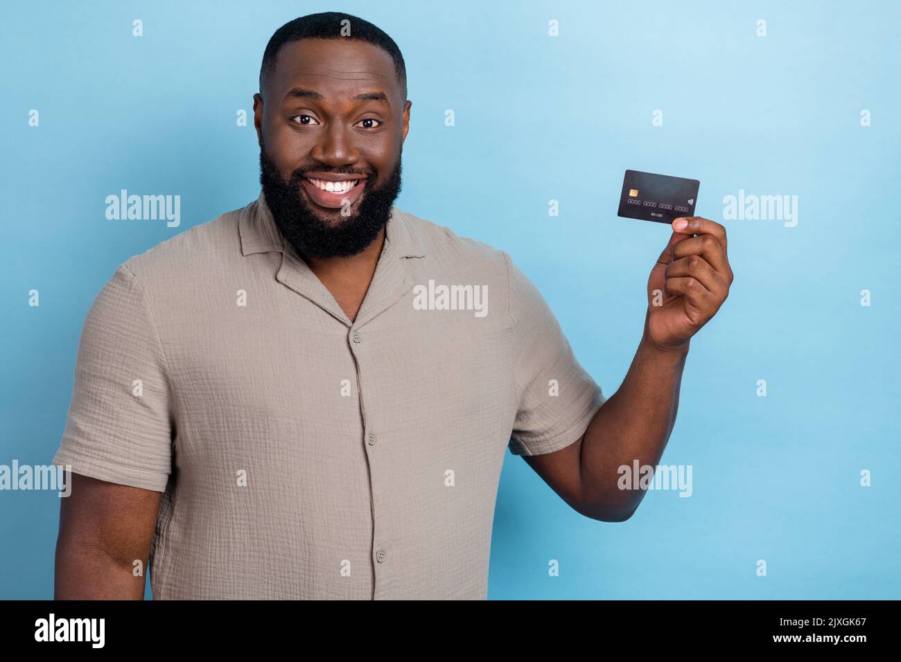 Photo of cheerful positive person hold demonstrate plastic debit card ...