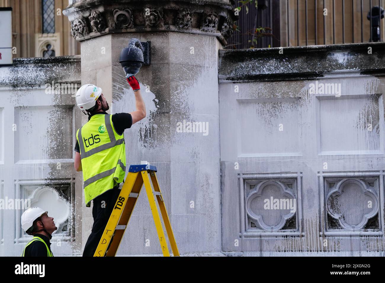 Workers clean paint from outside the Houses of Parliament in London ...