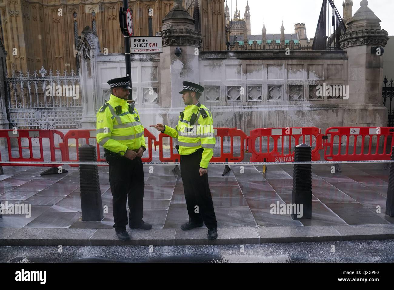 Police officers stand in front of paint covered walls outside the ...