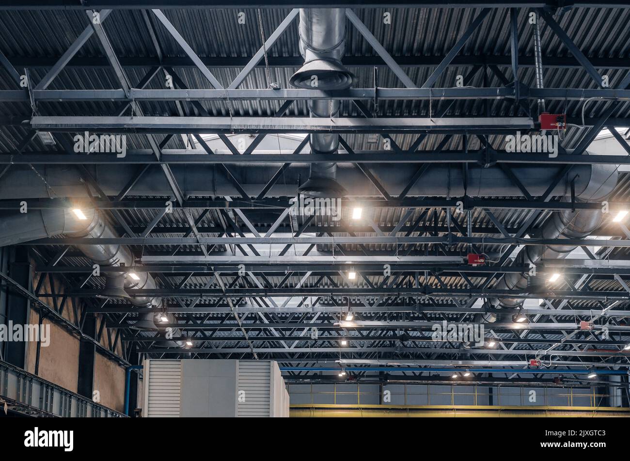 Metal trusses. Ceiling of large factory building with artificial ...