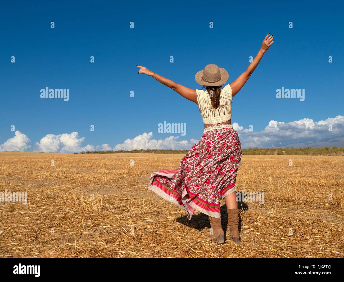 Back view of anonymous female in bohemian clothes with boots and hat ...