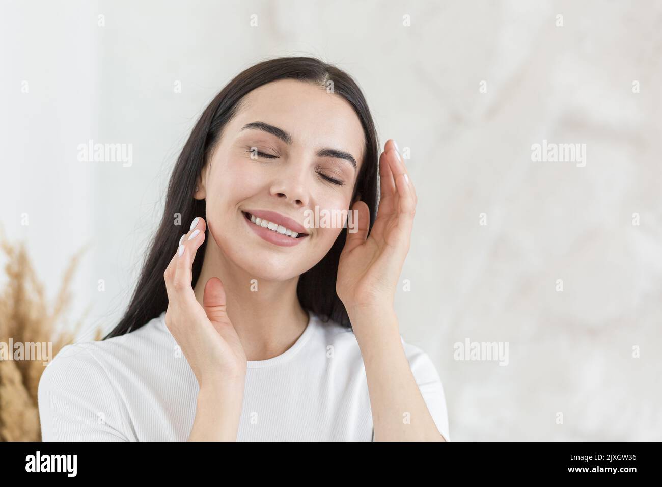Cosmetology. Close-up portrait of young beautiful woman in white t ...