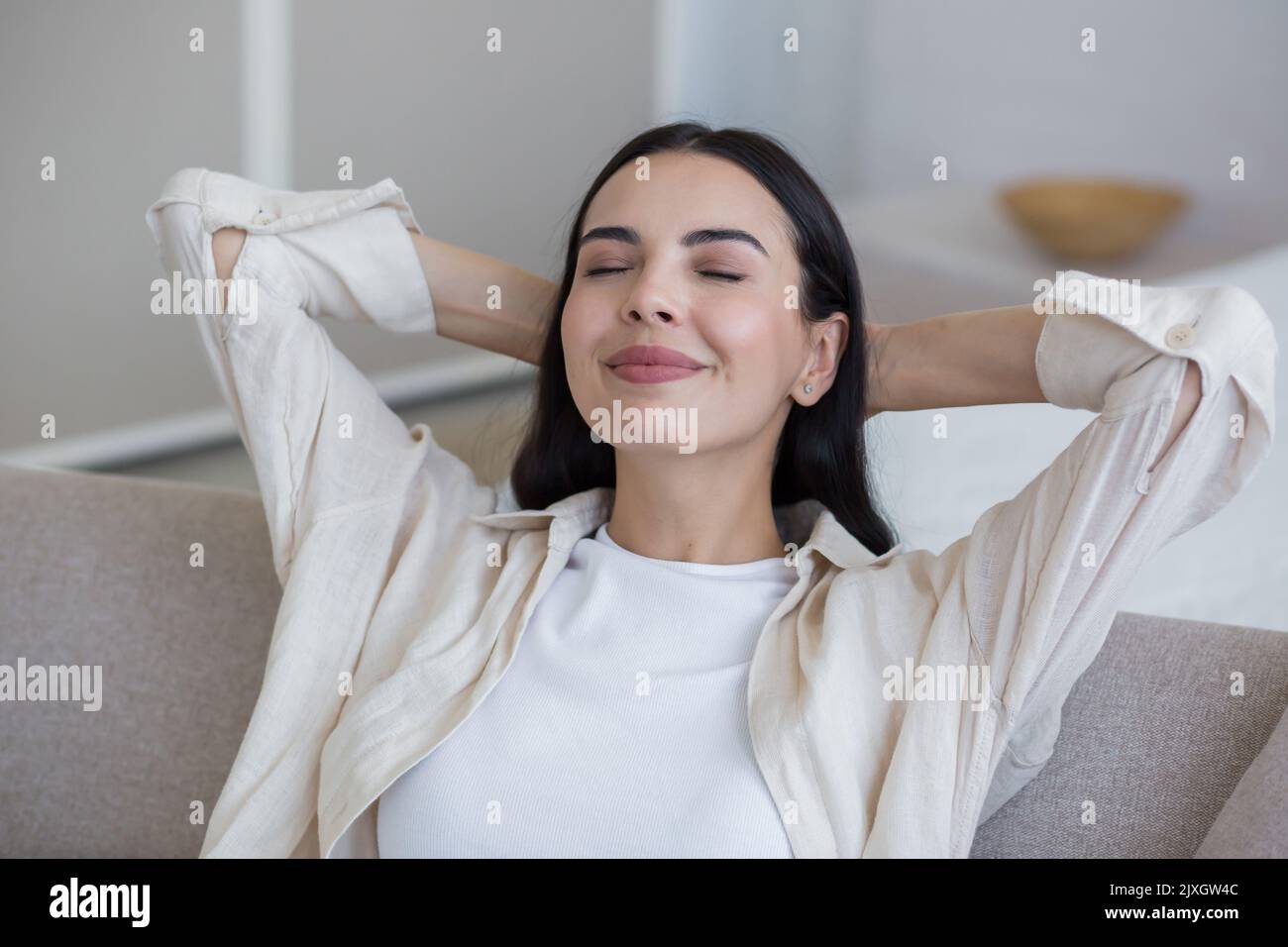 Close up photo. Happy young beautiful woman relaxing at home on sofa ...