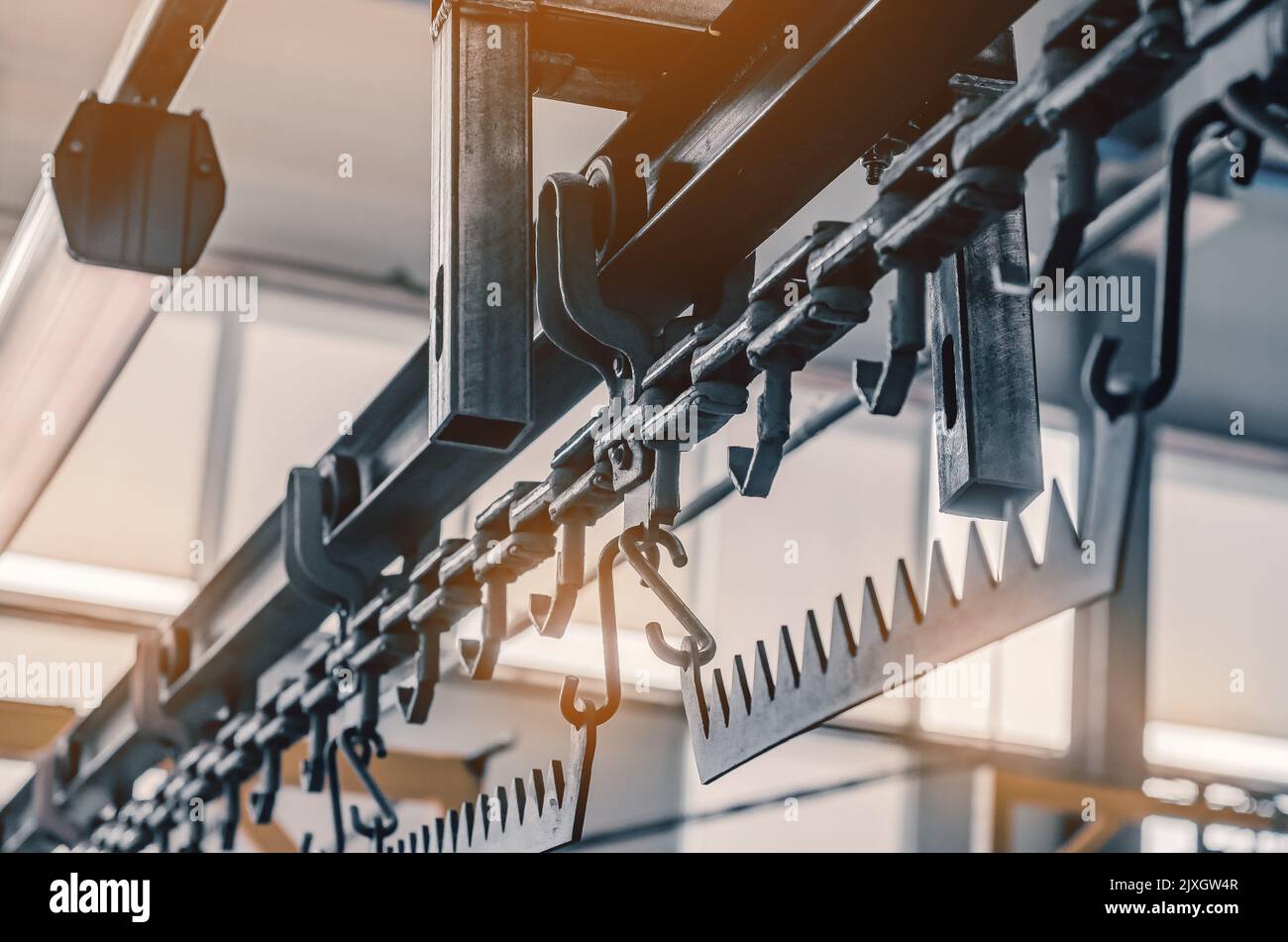 Product details are hung on metal hooks on chain in production shop ...