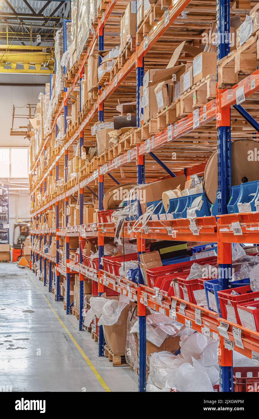 Storage with high shelves. Rows of shelves with boxes at factory ...